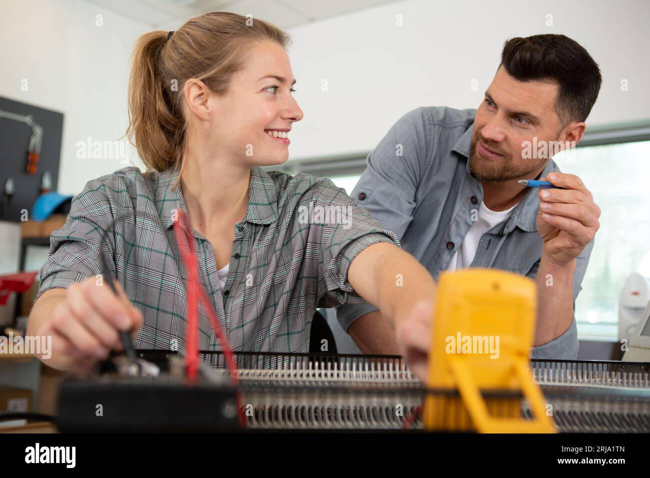 mentor and tradeswoman using a multimeter Stock Photo - Alamy