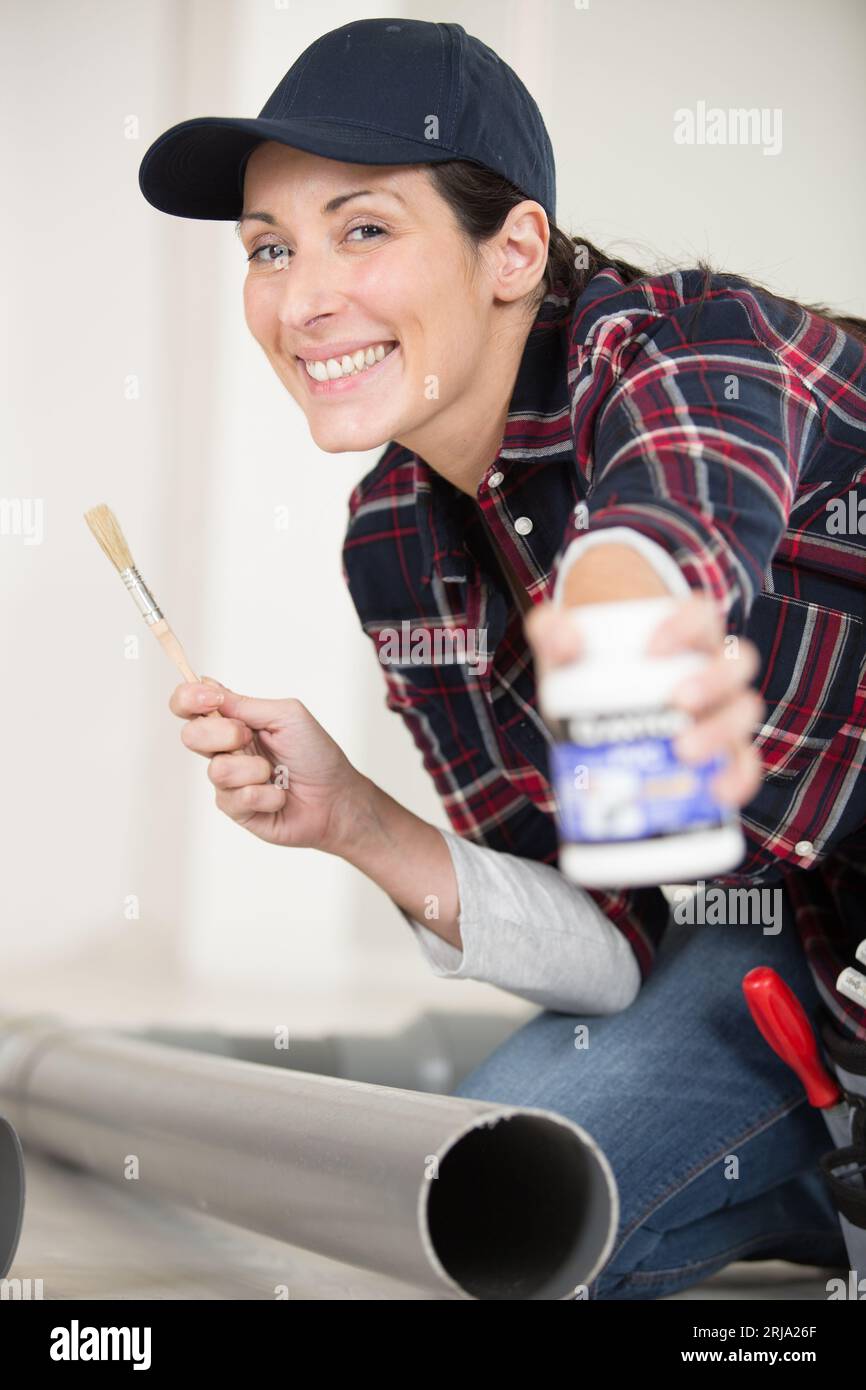 female worker painting tube with paintbrush Stock Photo - Alamy
