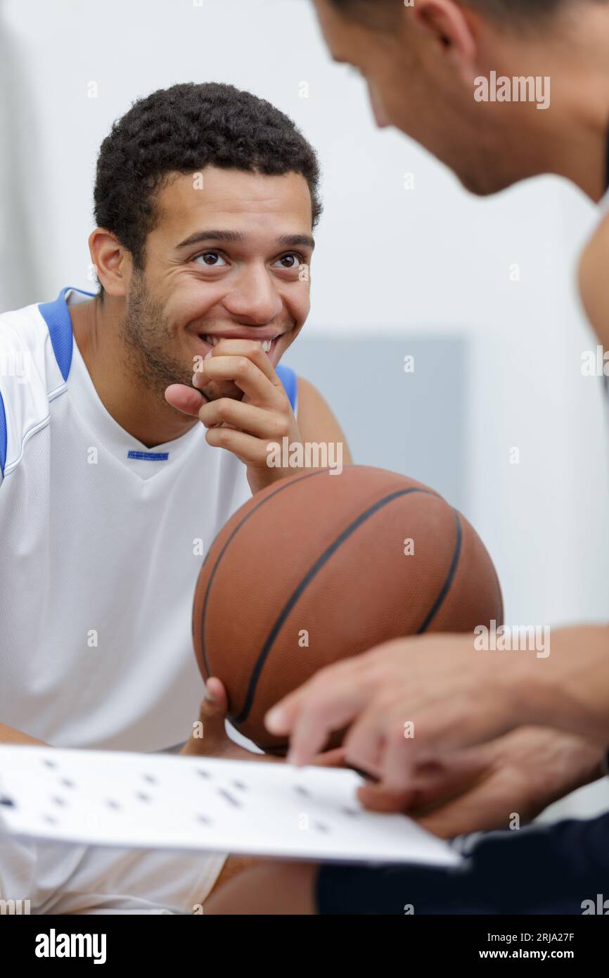 basketball player laughing while the coach is talking Stock Photo - Alamy