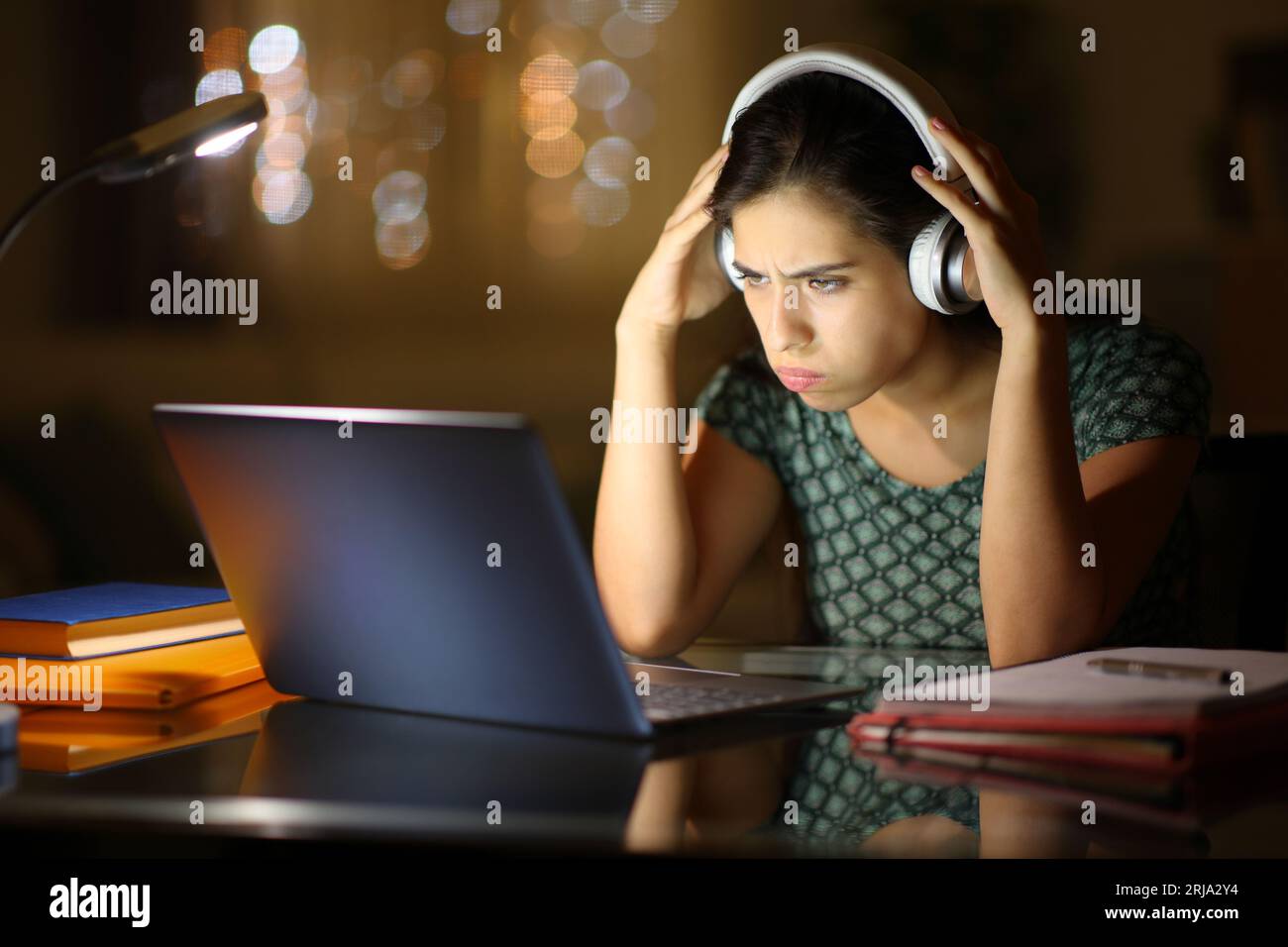 Stressed student e-learning with laptop and headphone in the night at home Stock Photo - Alamy