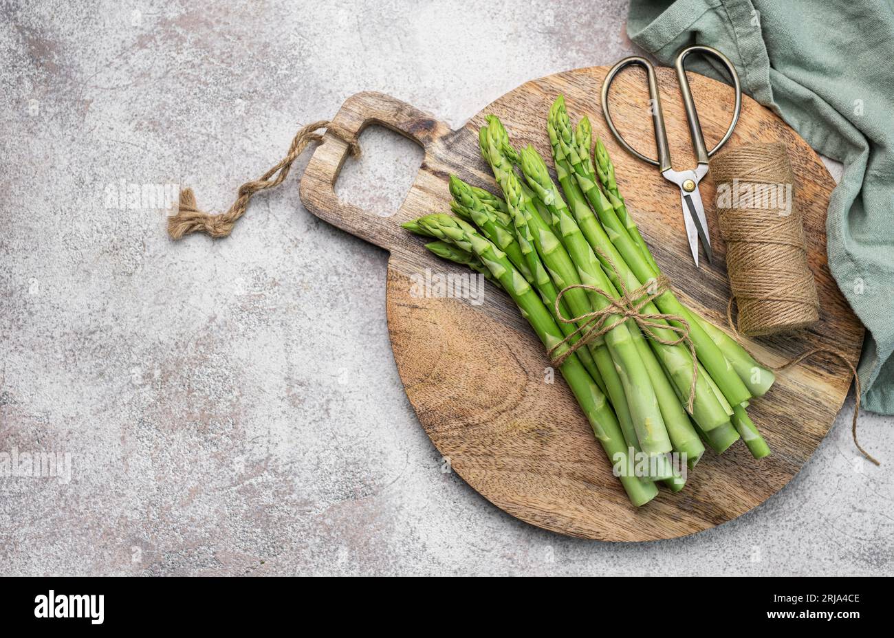 Fresh green asparagus with empty tag on grey concrete background. Flat ...