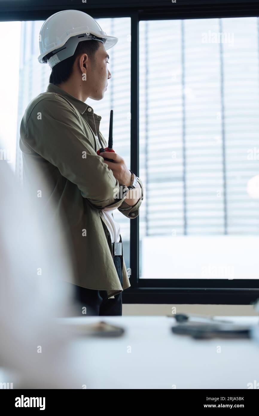 Architect standing in building in construction process with arms ...