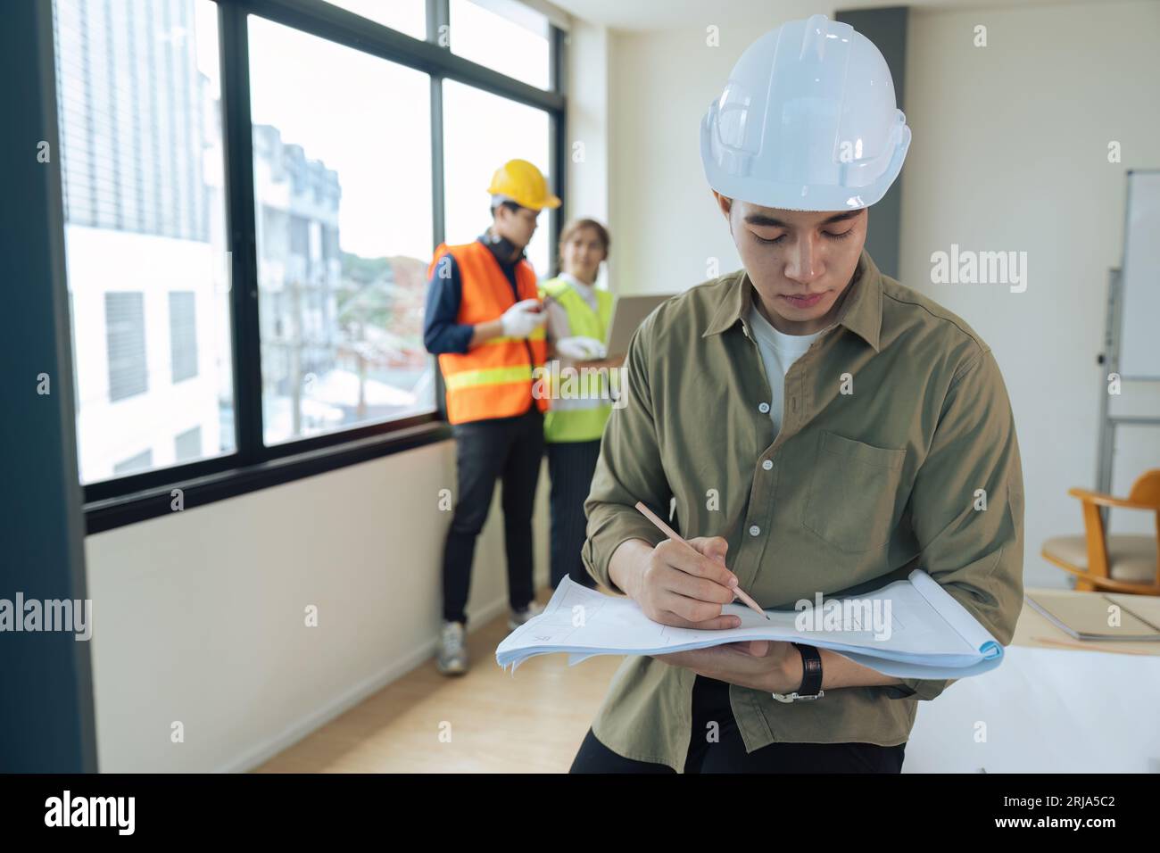 Engineer or architect holding a pencil working on the blueprint at the ...