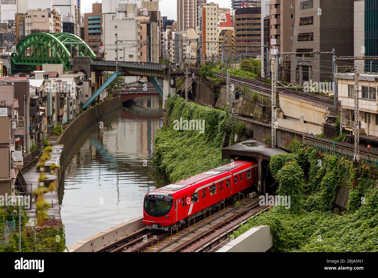 TOKYO, JAPAN - AUGUST 09 2023: Trains passing a busy intersection and ...
