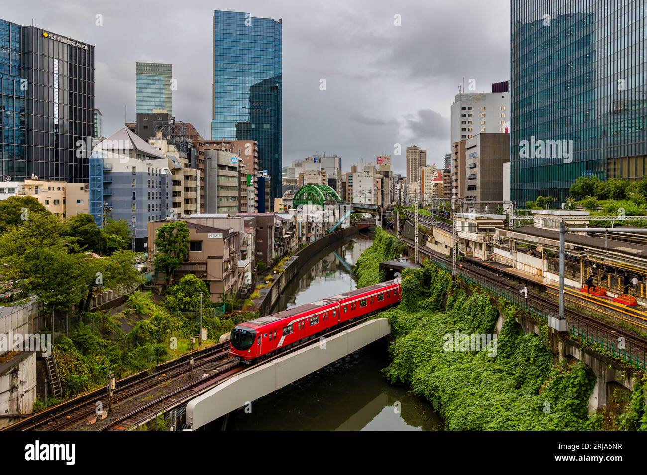 TOKYO, JAPAN - AUGUST 09 2023: Trains passing a busy intersection and ...