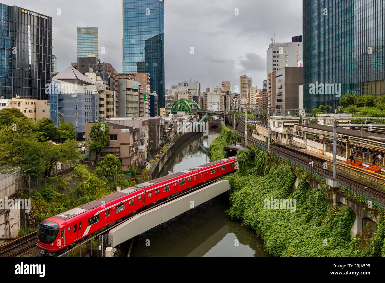 TOKYO, JAPAN - AUGUST 09 2023: Trains passing a busy intersection and tunnel over the Kanda ...