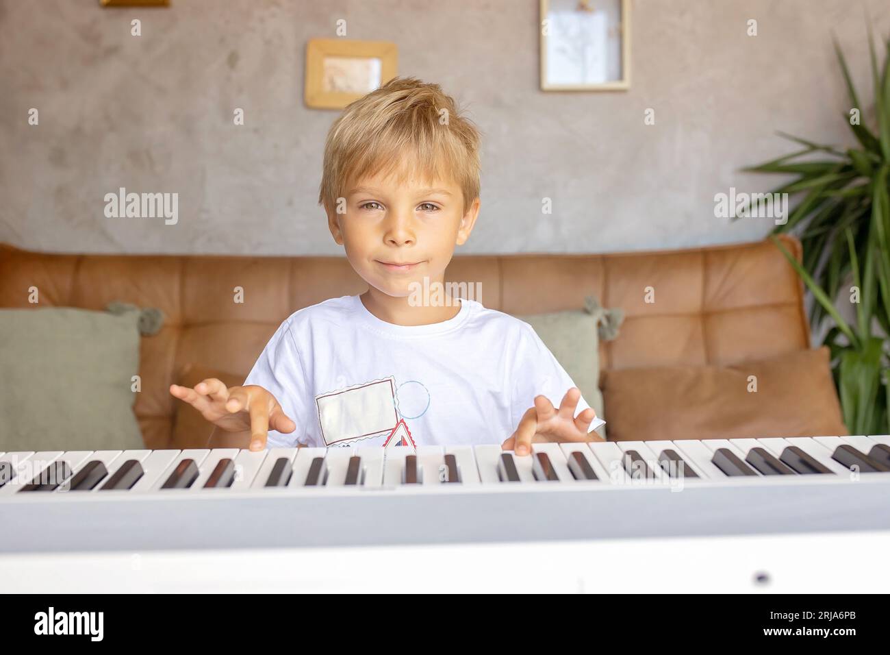 Child, blond boy, playing piano at home, learning Stock Photo - Alamy