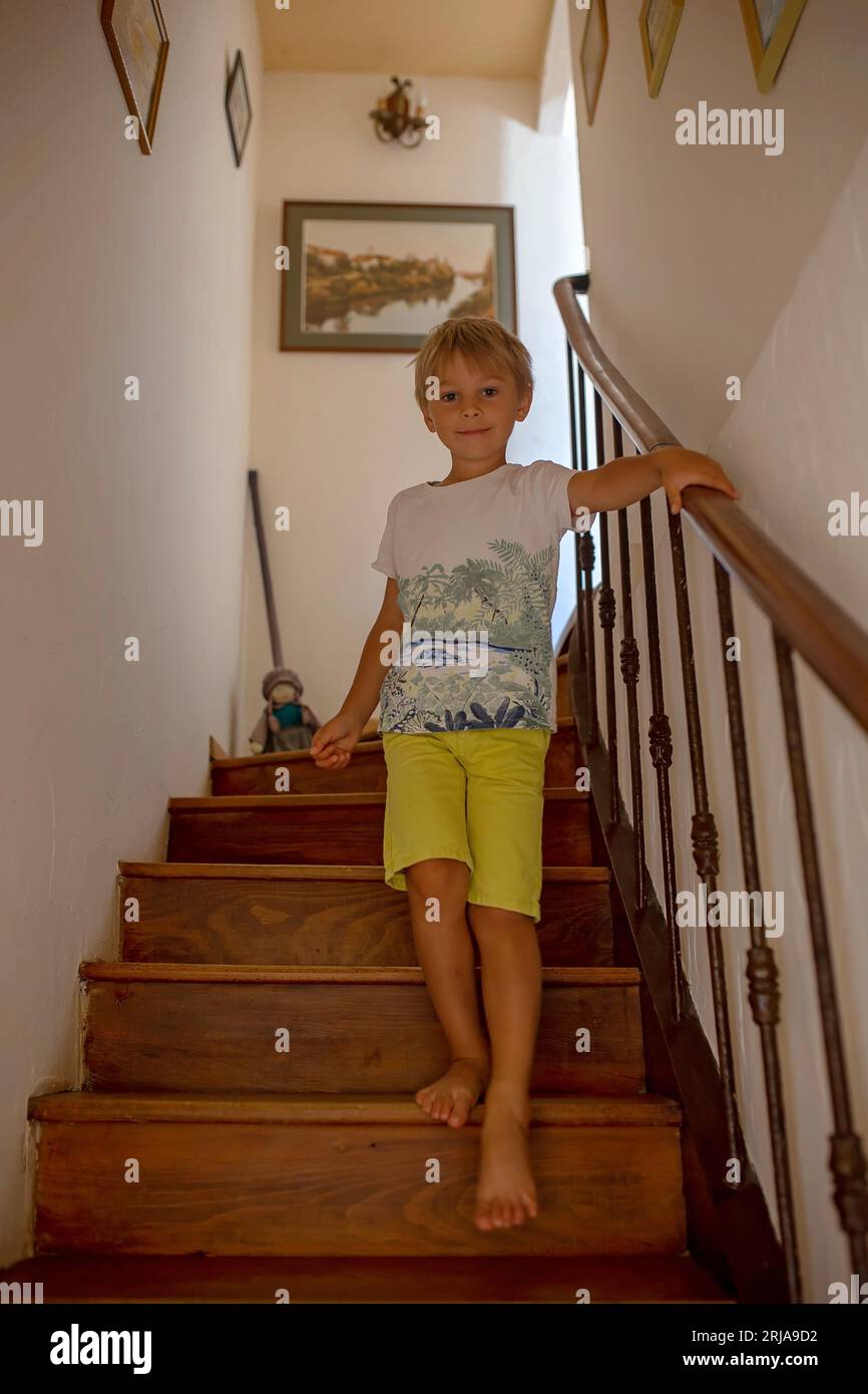 Sad little toddler child, boy, sitting sad on a staircase at home ...
