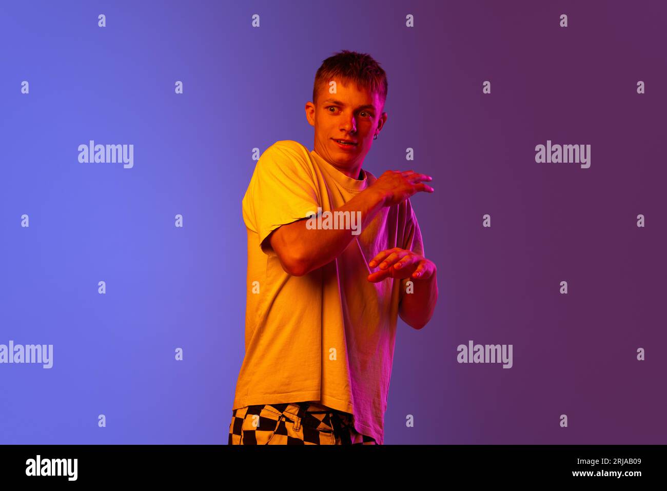 Shock and surprise. Young guy standing with funny scared face against ...