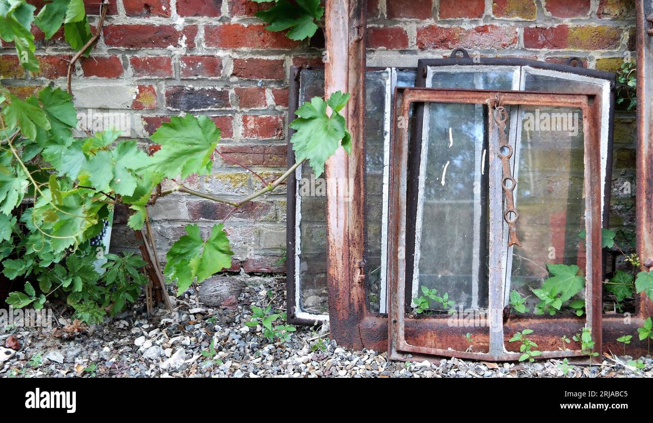 A pair of vintage window frames and old windows against a masonry wall ...