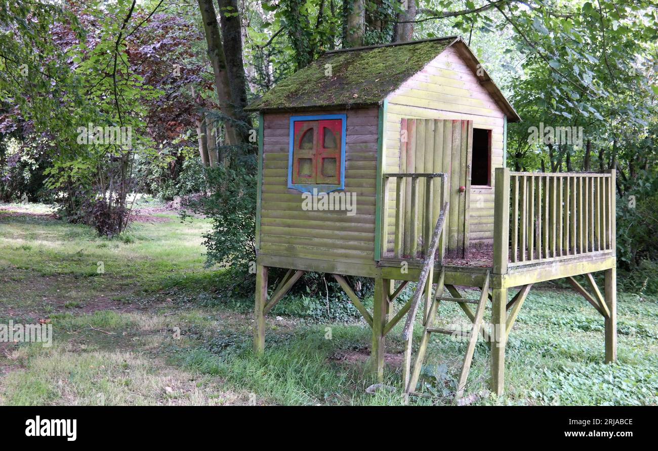 An old playhouse with a veranda in a forest. A small wooden house that ...