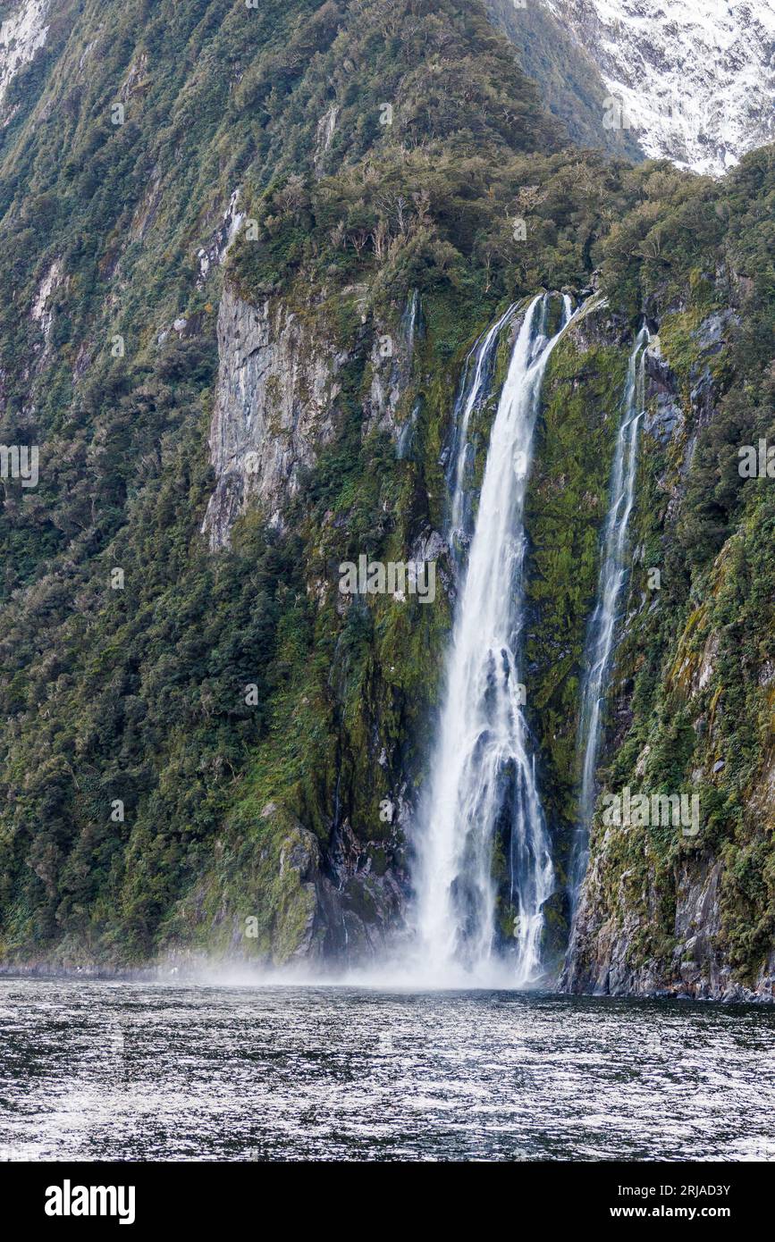 A waterfall that flows from a cliffside into the oceans of the Milford ...