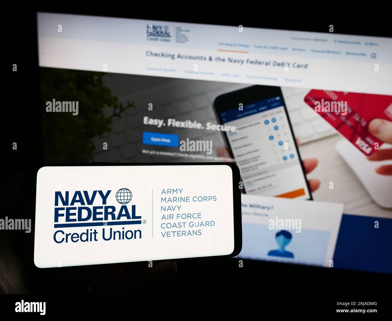 Person holding mobile phone with logo of financial instituation Navy ...