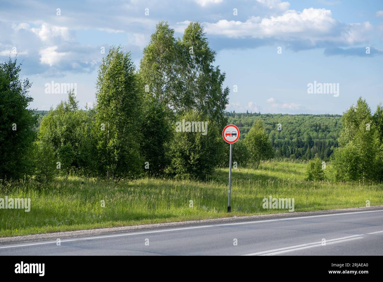 A road sign Overtaking is prohibited on a suburban highway through ...