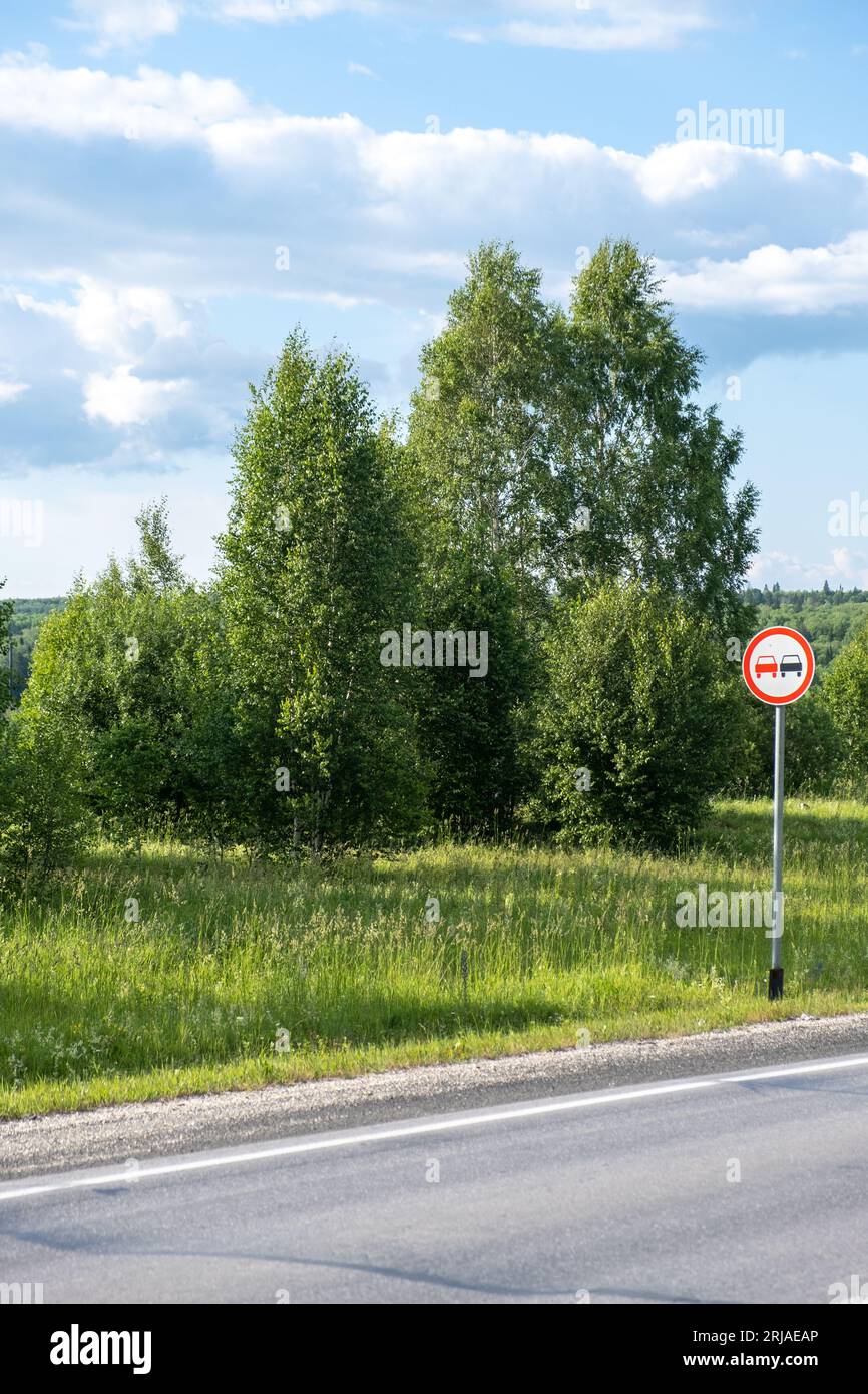 A road sign Overtaking is prohibited on a suburban highway through ...