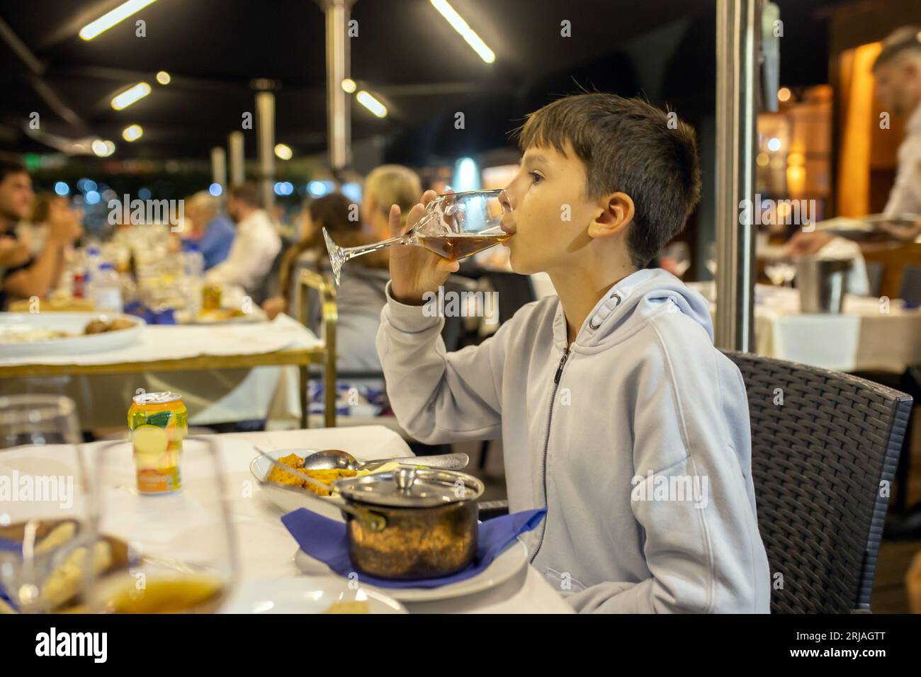 Cute child, boy, eating fish for dinner in a restaurant in Portugal ...