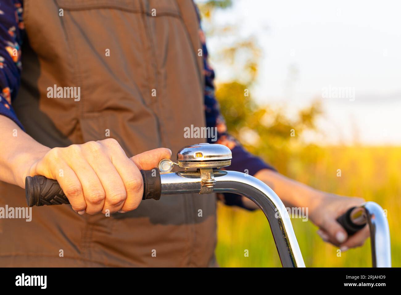 female finger presses on mechanical bicycle bell. hand holding the ...