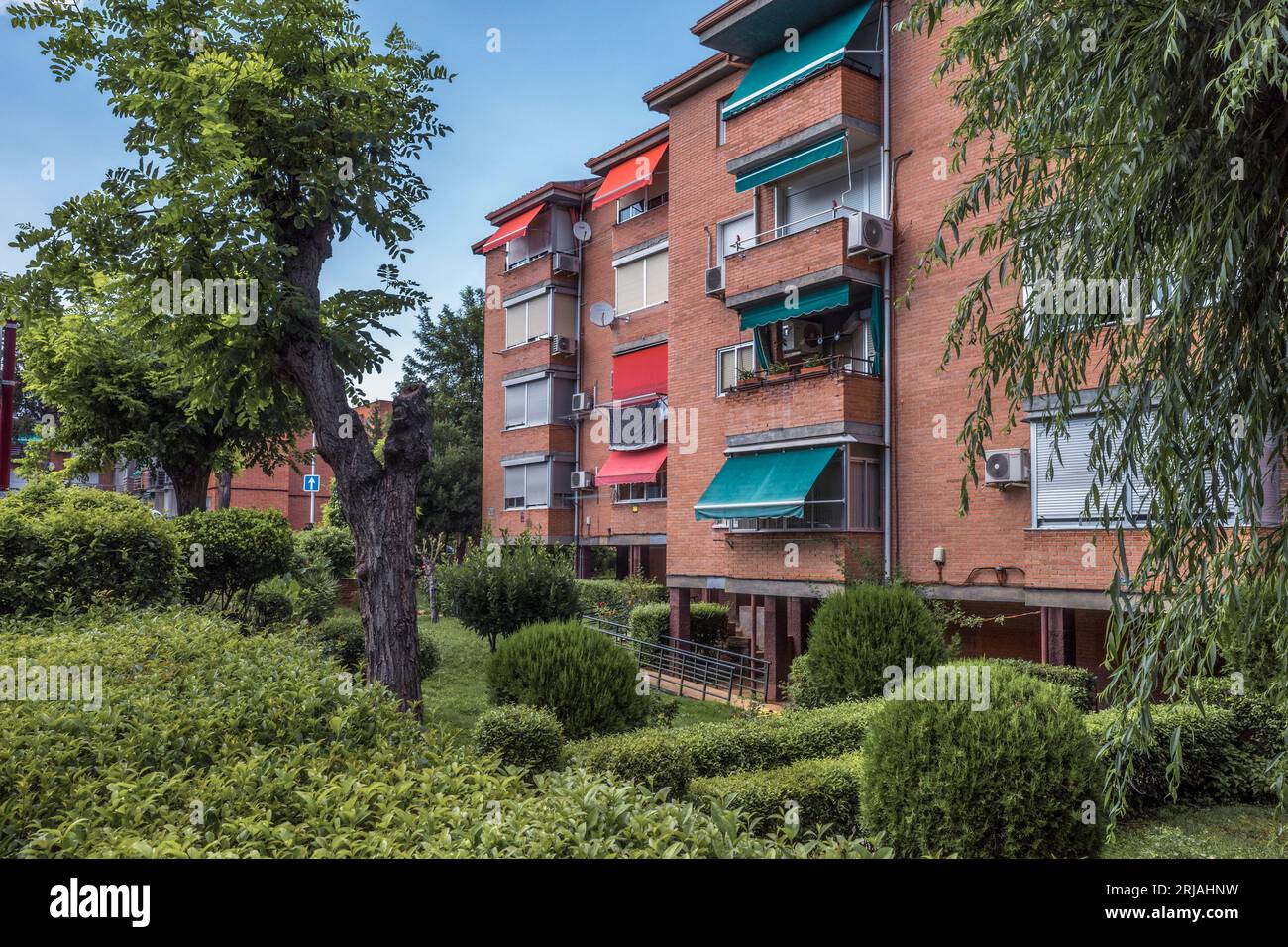 New red brick apartment building in a new development with a garden ...