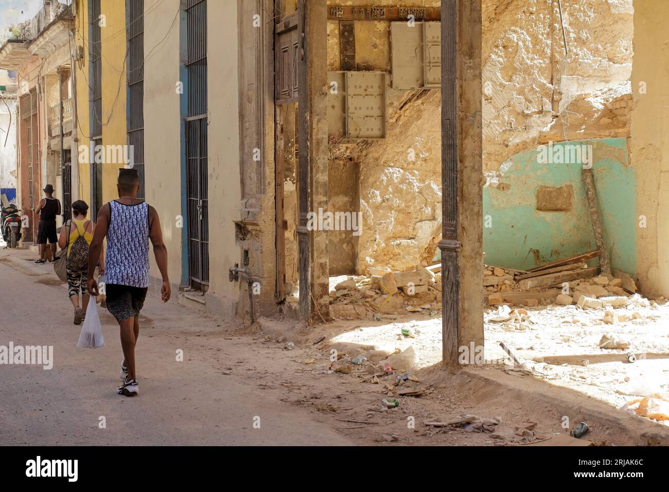 Havana, Cuba, a man carries a plastic bag while walking by a collapsed ...