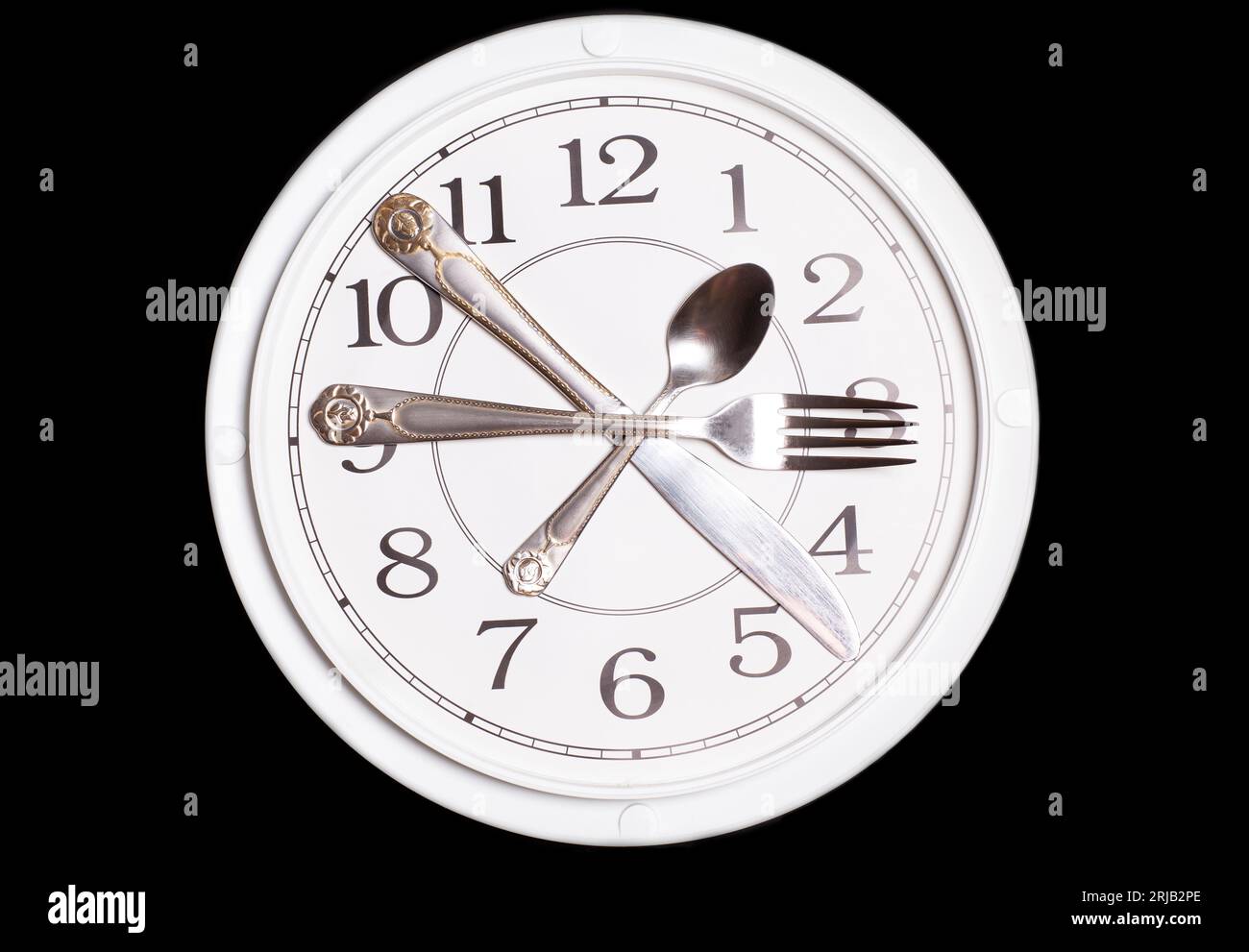 Clock made of knife, spoon and fork on black background Stock Photo - Alamy
