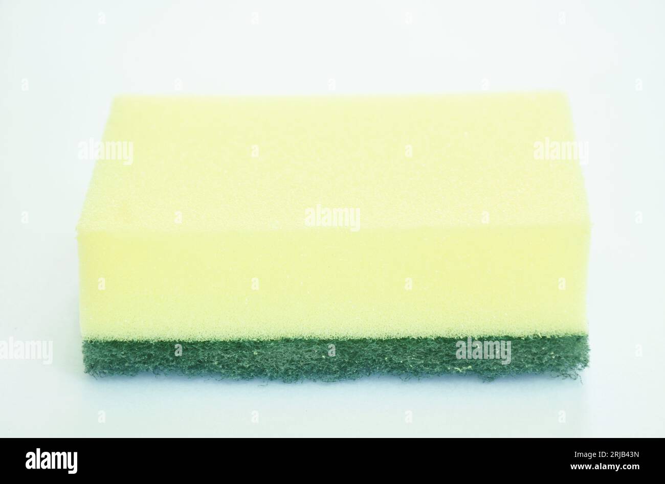 yellow and green scrub sponge with liquid washing on white background ...