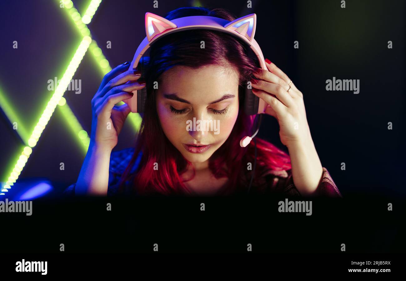 Girl adjusts her gaming headset as she continues to engage with the ...