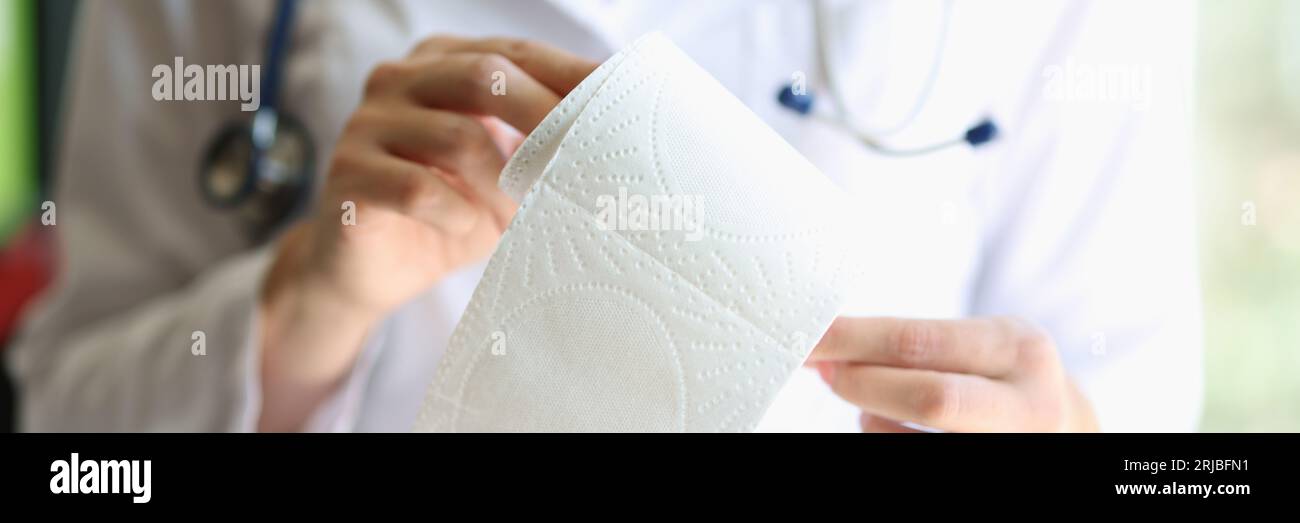 Female doctor holding roll of white toilet paper close-up Stock Photo ...