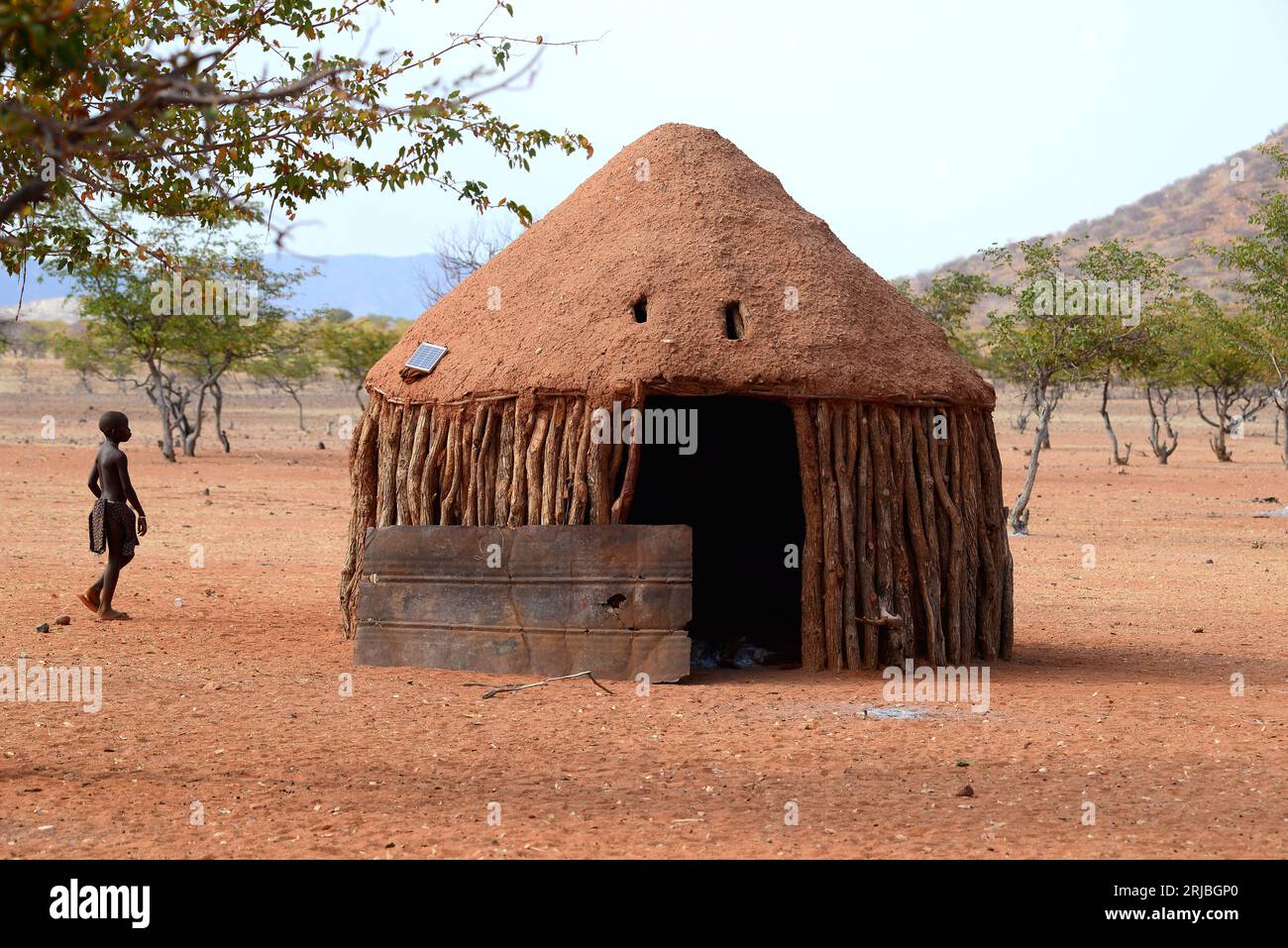 Traditional hut in a Himba village with a little solar photovoltaic ...