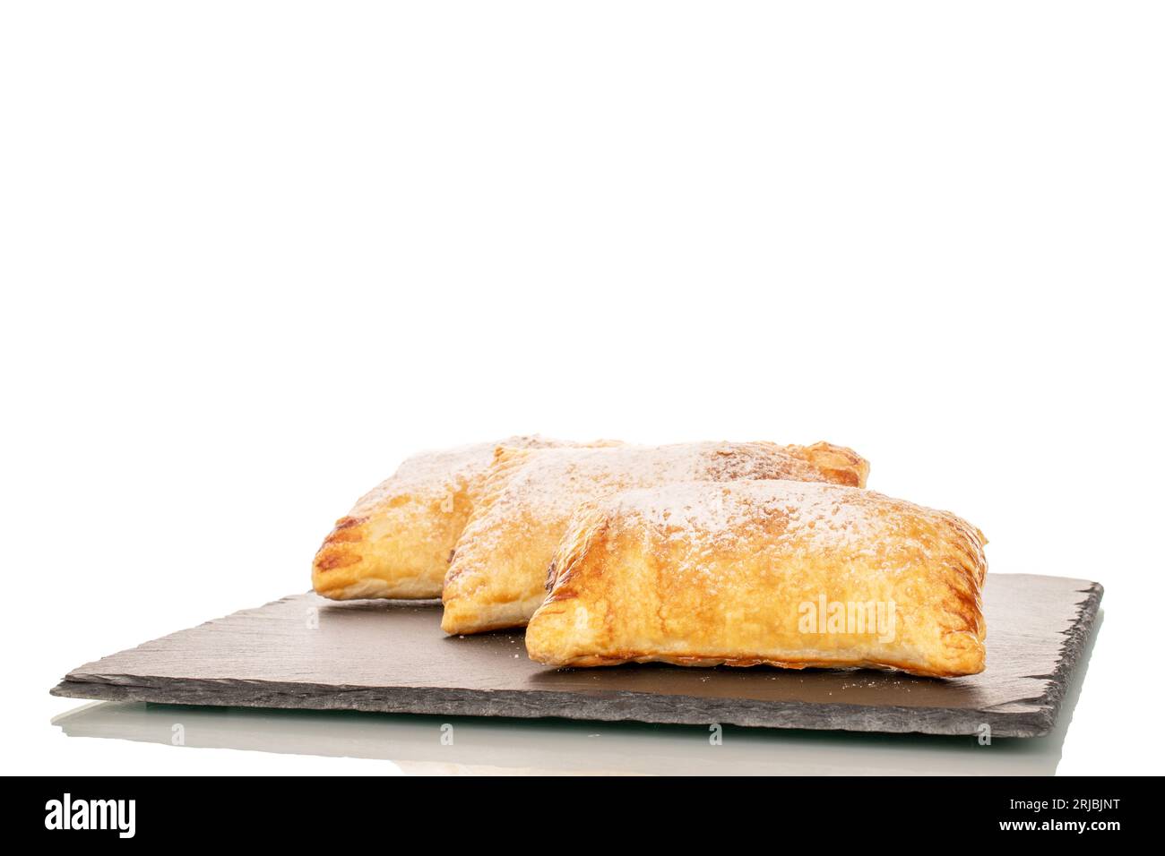 Three aromatic puff pastry buns with apples on slate stone, macro ...