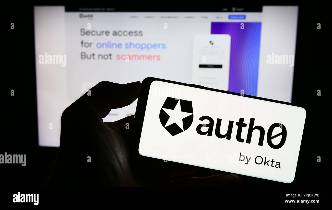 Person holding mobile phone with logo of American identity platform company Auth0 by Okta on ...