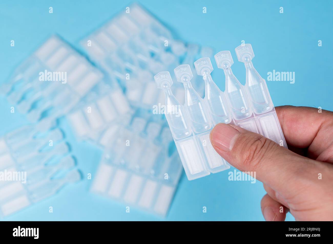 Disposable eye drops isolated on blue background Stock Photo - Alamy