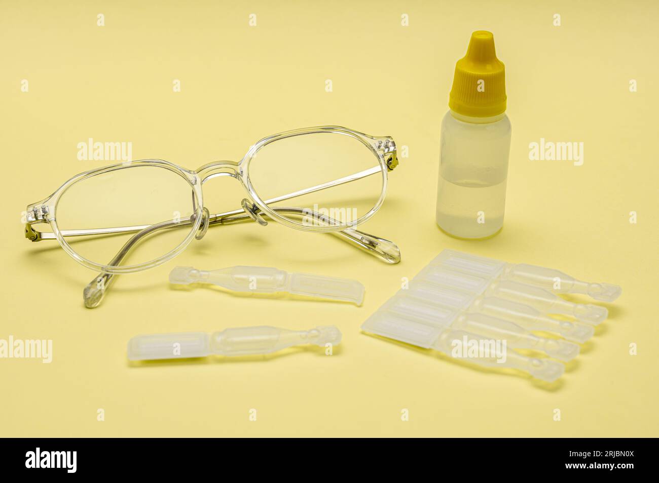 Glasses and disposable eye drops isolated on yellow background Stock ...