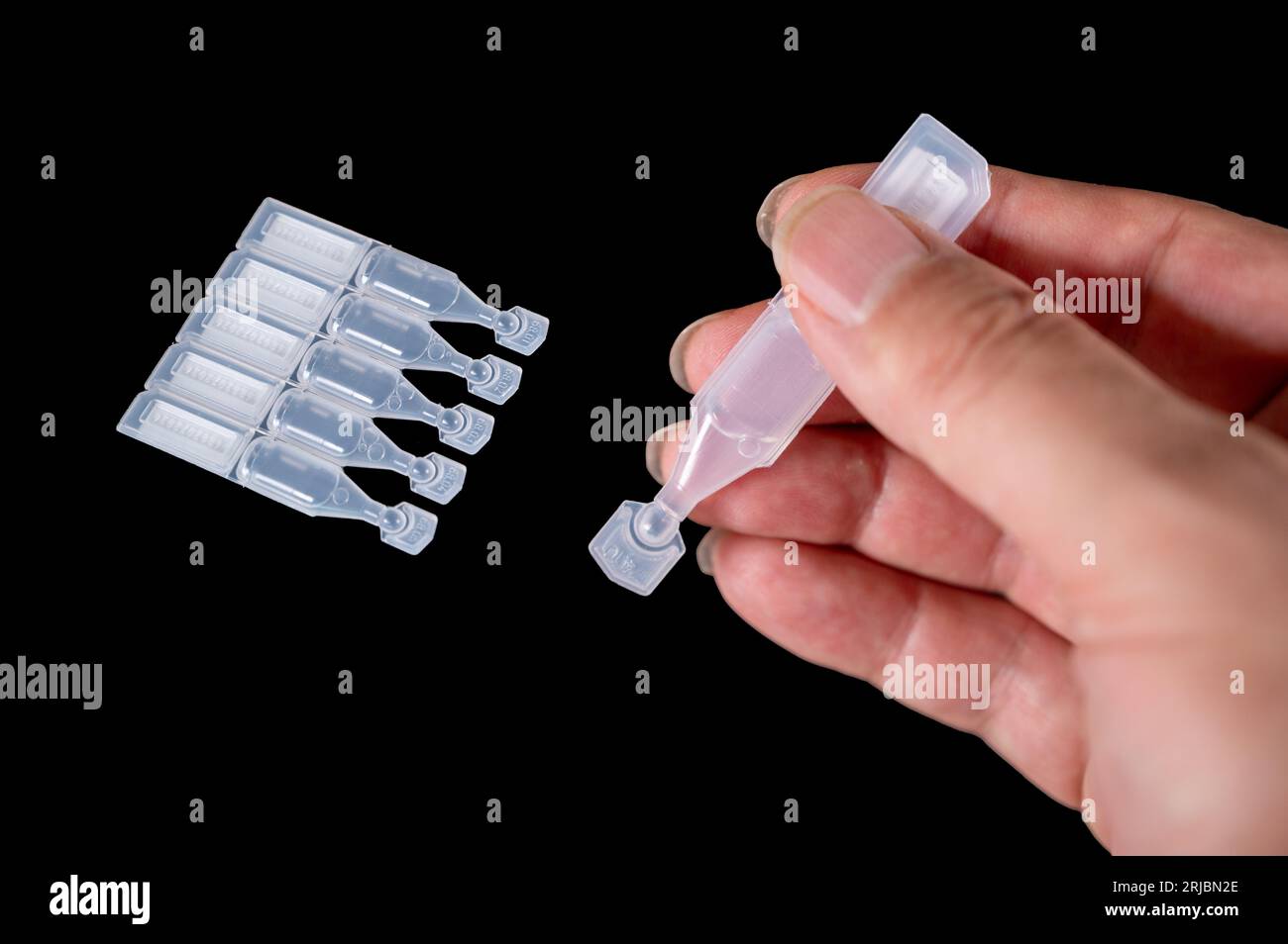 Disposable eye drops isolated on black background Stock Photo - Alamy