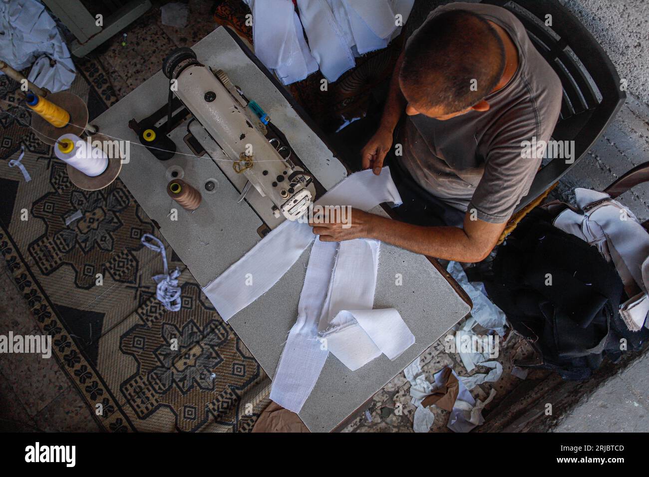 Gaza City, Palestine. 22nd Aug, 2023. A Palestinian tailor makes ...
