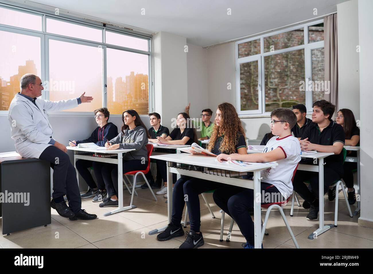 the teacher teaches to a class full of elementary boys and girls ...