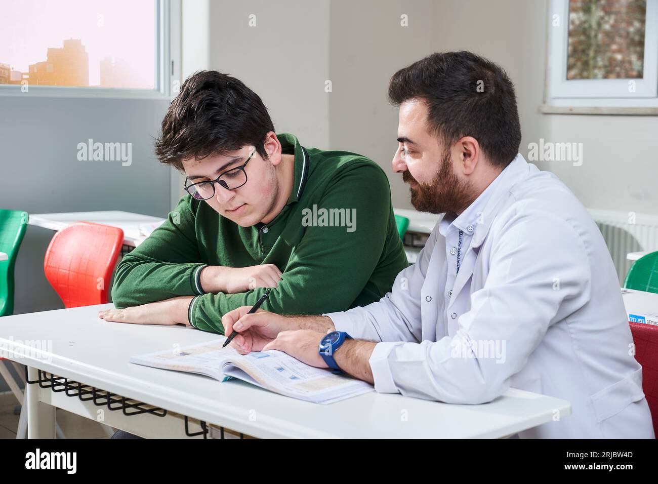 the teacher teaches to a class full of elementary boys and girls ...