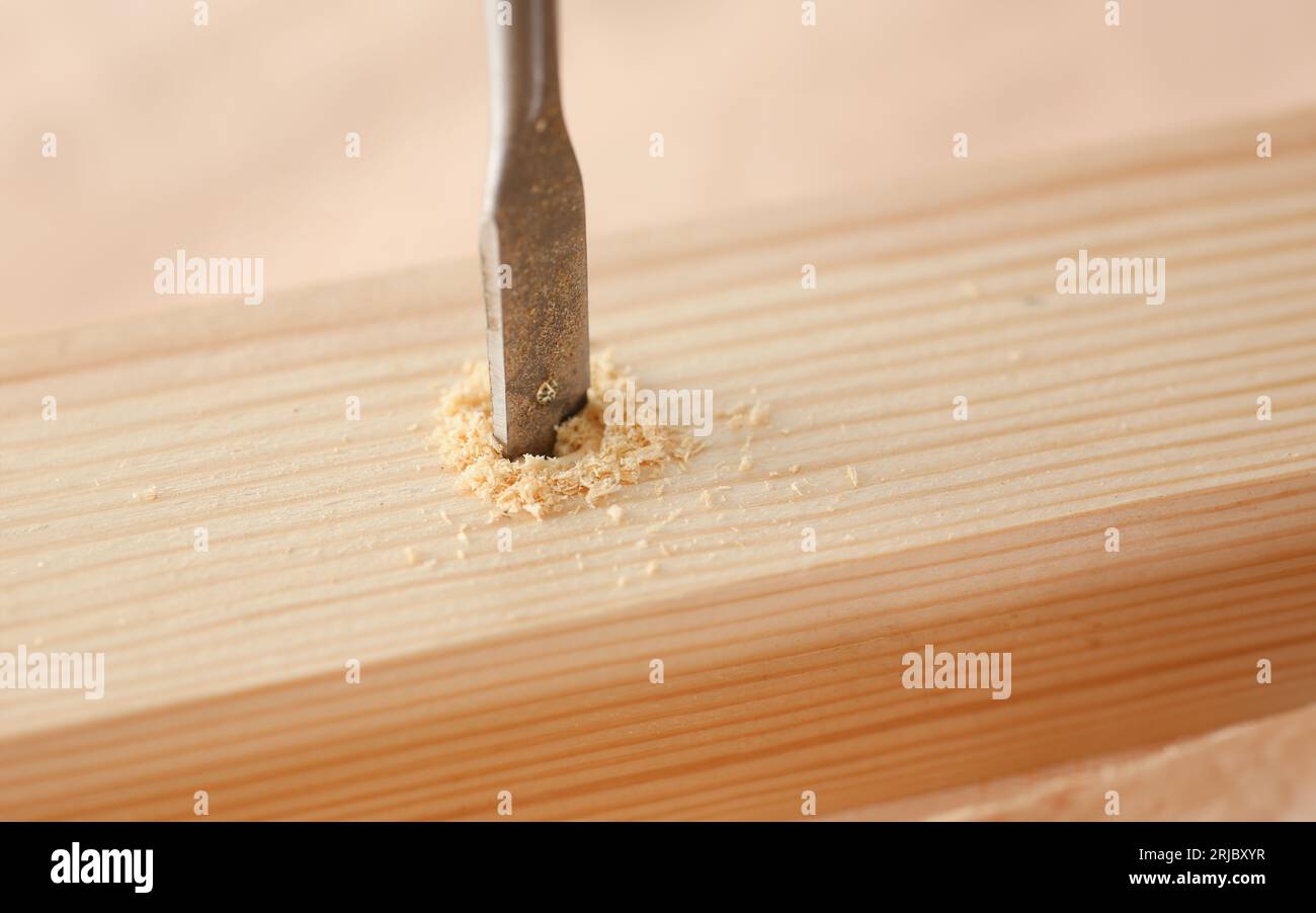 Flat drill bit make hole in wooden bar Stock Photo - Alamy