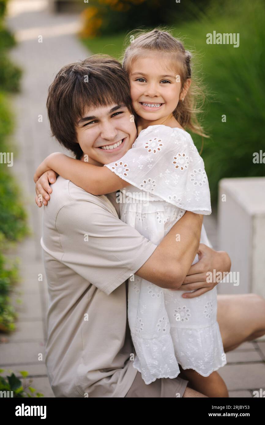Portrait of happy and beautiful sister with her cousin. Adorable little girl and handsome ...