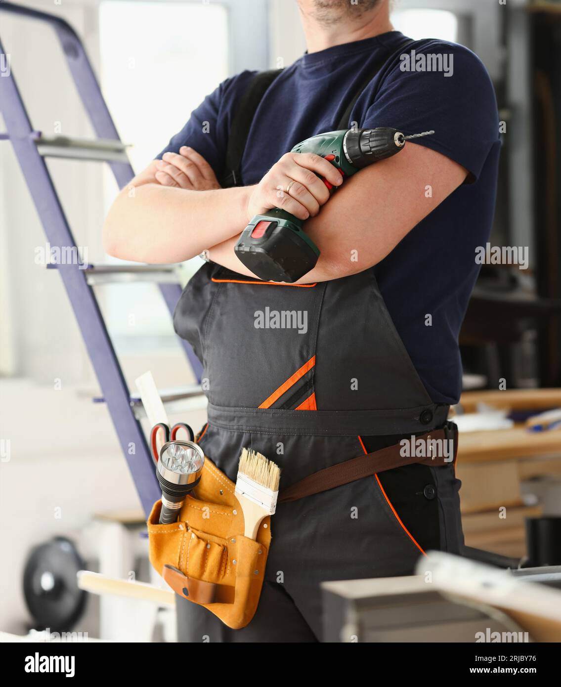 Arms of worker using electric drill Stock Photo - Alamy