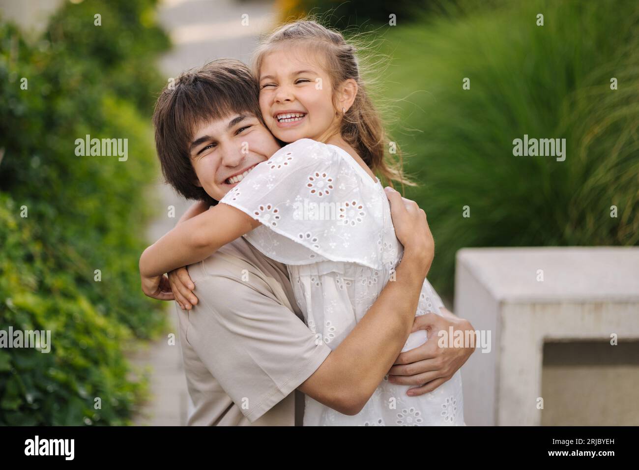 Portrait of happy and beautiful sister with her cousin. Adorable little girl and handsome ...