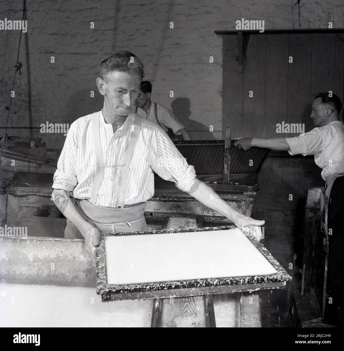 1950s, historical, a male worker with a iron cast of plaster mold from ...