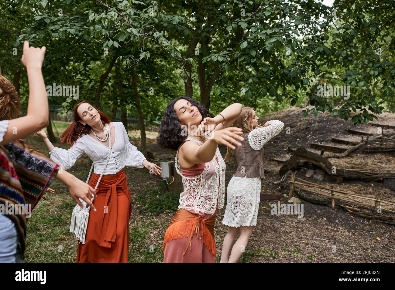 multiethnic girlfriends in stylish clothes dancing with closed eyes in ...