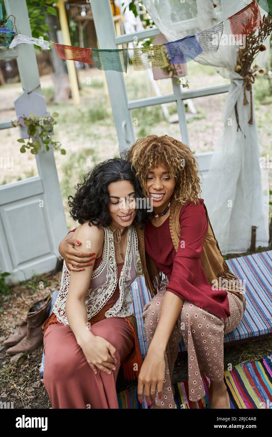 smiling african american woman hugging multicultural friend outdoors in ...
