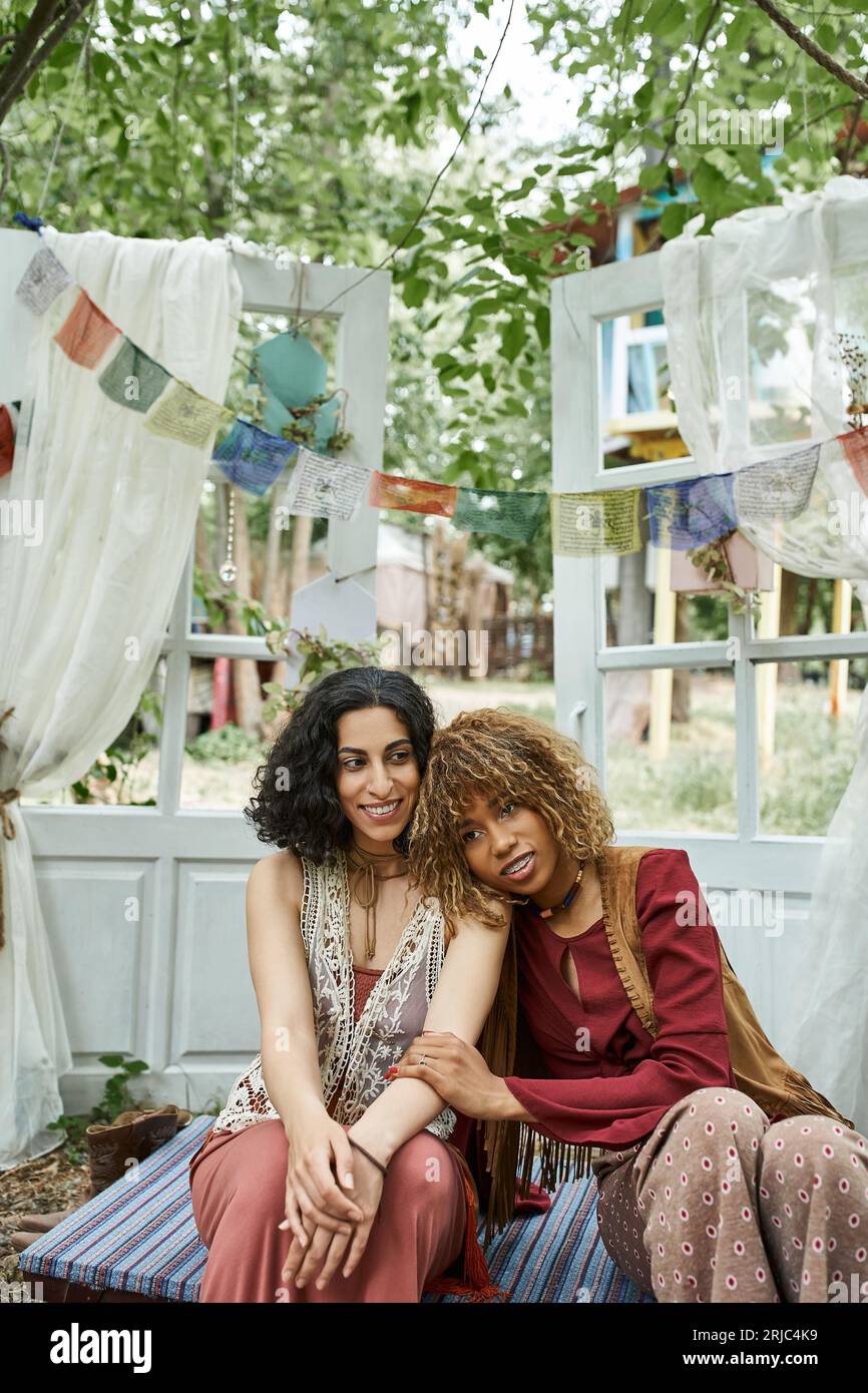 smiling african american woman hugging multiracial friend in boho ...
