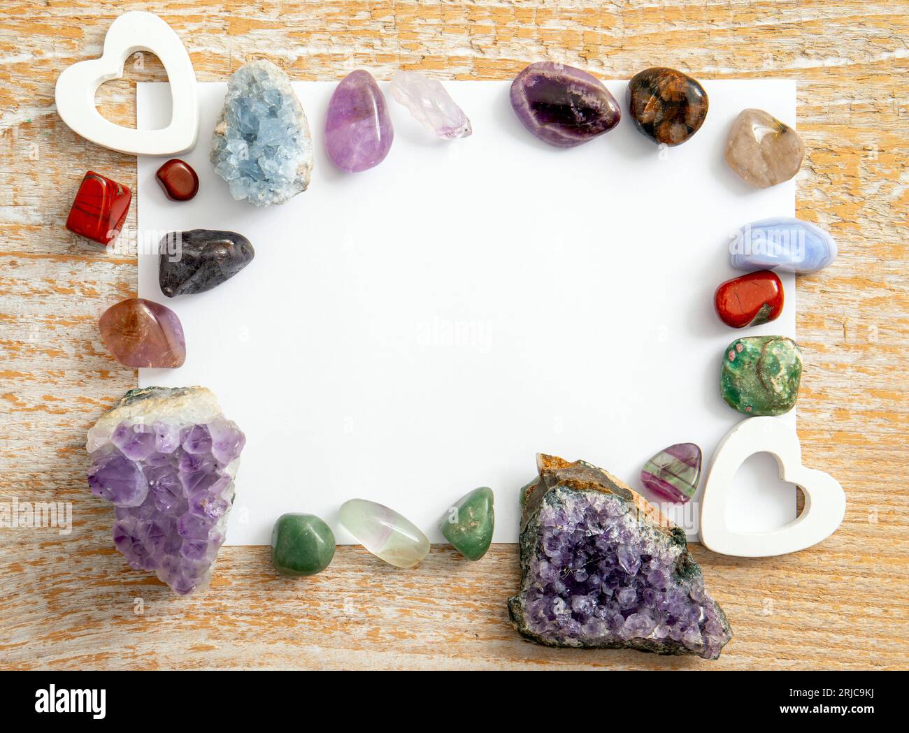 Frame made with colorful crystal gemstones with white empty paper page ...