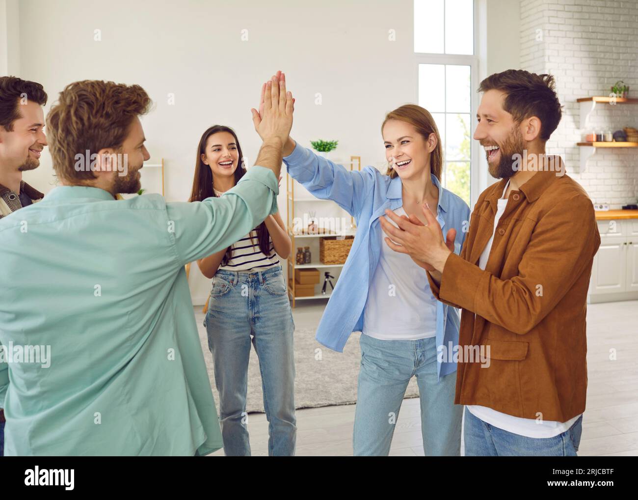 Group of excited happy friends greeting each other giving high five ...