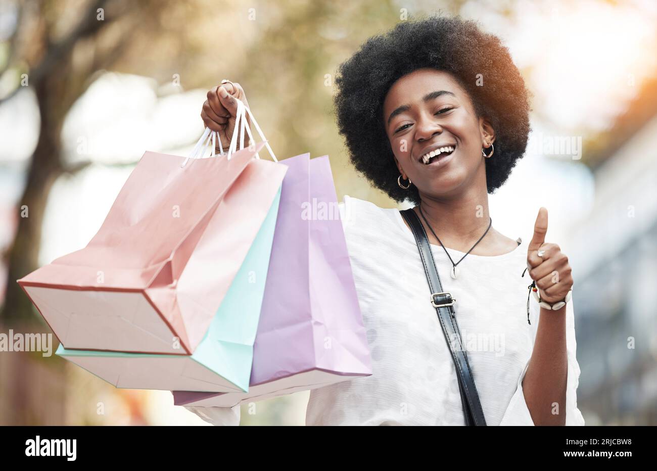 Woman, shopping bag and thumbs up in city for success, thank you and ...