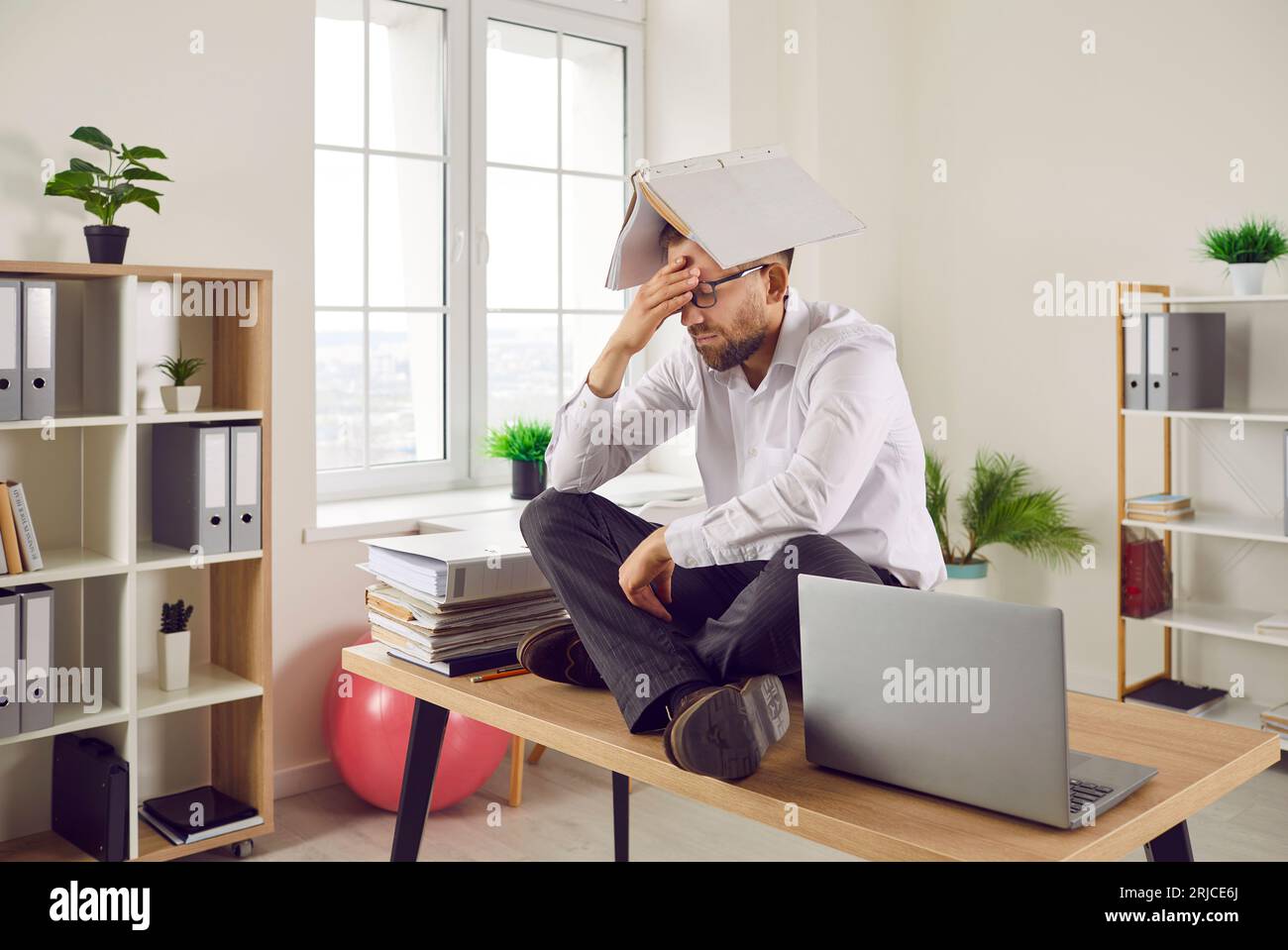 Tired, stressed, overworked man with headache sitting on his working ...