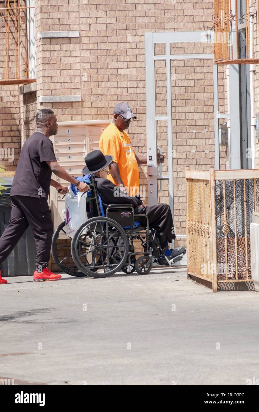 A hasidic man in a wheelchair gets an assist from two aid. In ...