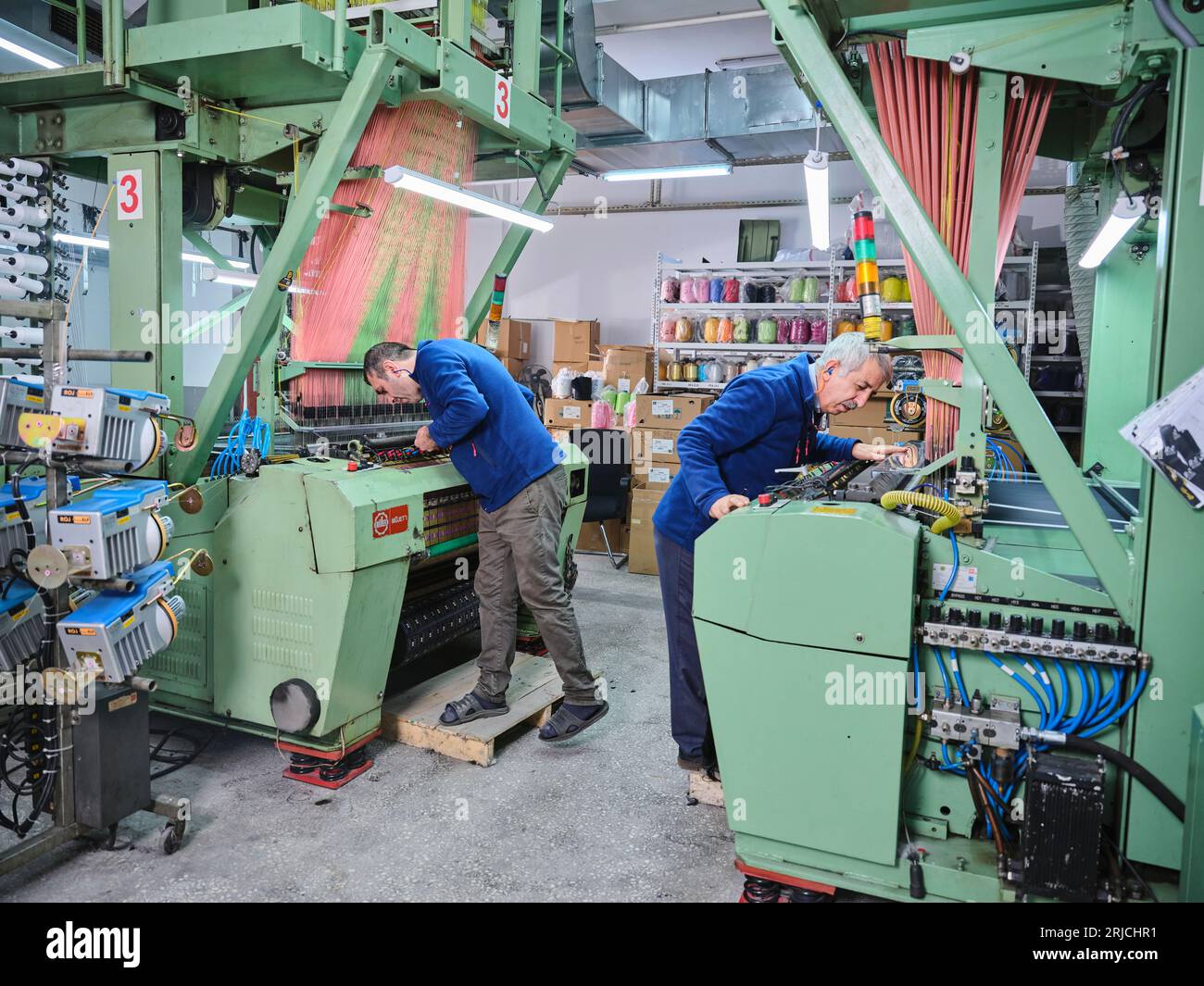 people working in a sticker printing factory. worker uses a stickier ...